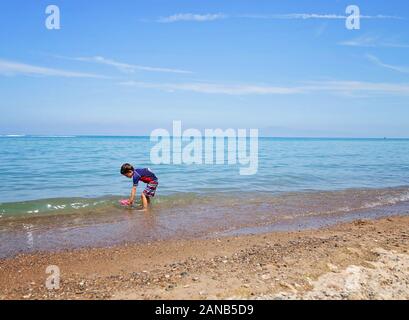 Little boy playing on the beach Stock Photo - Alamy