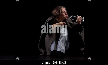 Alcoholic woman drinking greedily vodka from bottle, harmful addiction ...