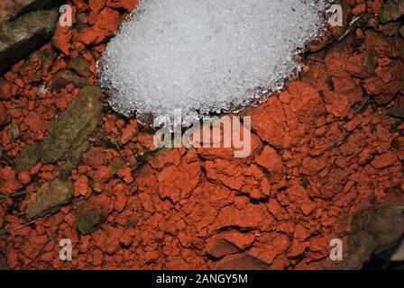 Melting snow on crumbling wall of red bricks, grunge background Stock ...