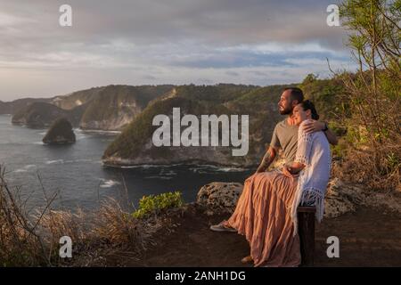 Couple enjoying view from Banah Cliff of Nusa Penida island, Indonesia ...