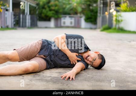 Asian man having heart attack or heart failure at street in home ...