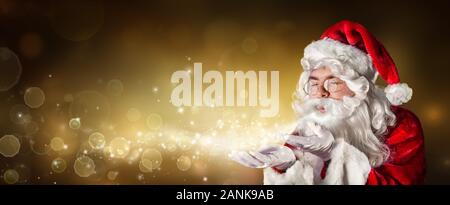 Santa Claus Blowing Magic Christmas Stars In Snowy Night Stock Photo - Alamy