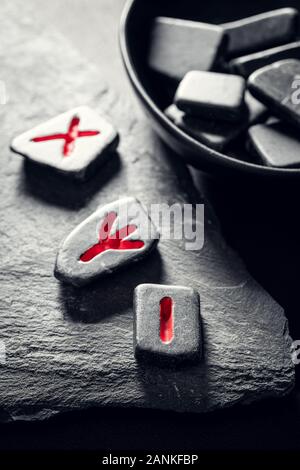 Rune stones made of Celtic language and vintage book on old table Stock ...