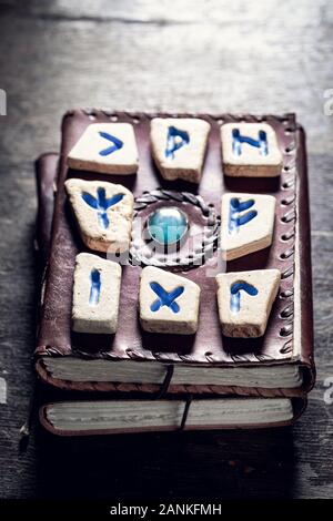 Rune stones made of Celtic language and vintage book on old table Stock ...