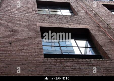 Alleyway with glass windows and a brick wall of a building Stock Photo ...