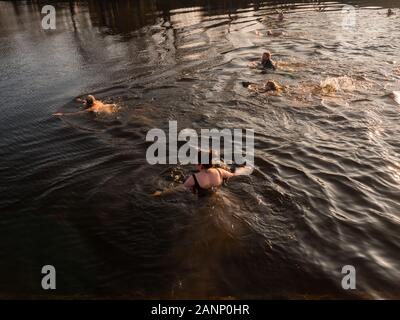 People swim in an outdoor swimming pool in London, Tuesday, June 23 ...