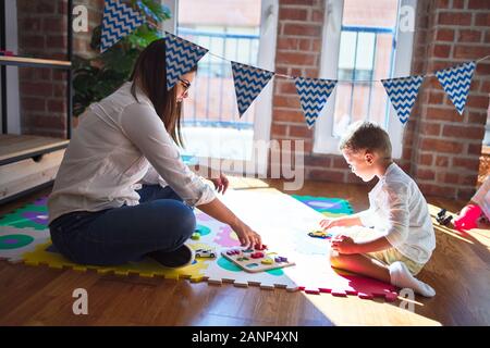 Adorable toddler learning numbers using maths puzzle around lots of ...