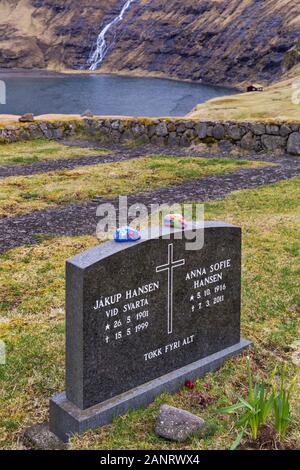 Headstone in church cemetery with waterfall at Saksun ancient village ...