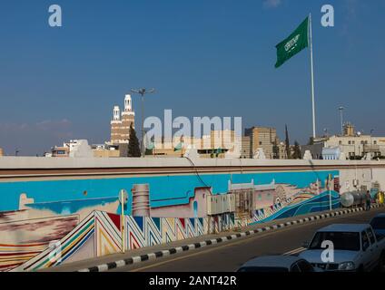 Saudi arabian flag in front of a fresco, Asir province, Abha, Saudi ...
