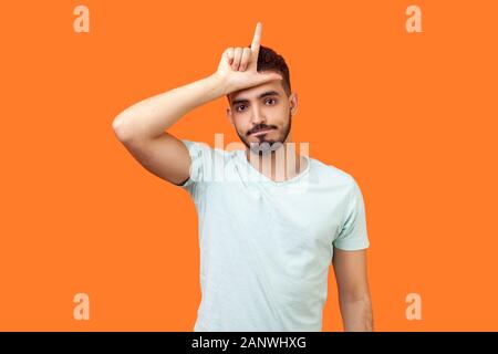 Arab man with beard standing over blue background afraid and terrified ...