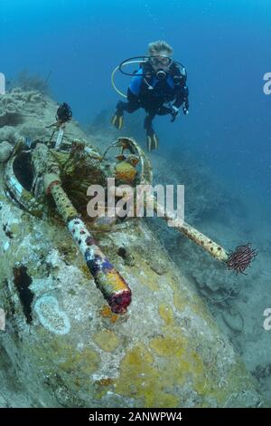 A female diver investigating the machine guns of a B-25 Mitchell Bomber ...