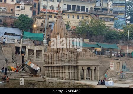 India, Uttar Pradesh, Varanasi, Scindia Ghat, Shiva temple sinking into ...