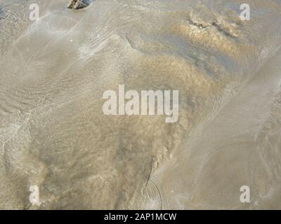 Water flowing over sand forming pattern Stock Photo - Alamy