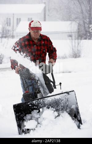 Man pushing snow blower during storm Stock Photo - Alamy
