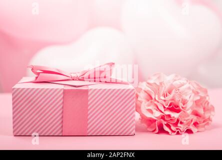 Heart shaped balloon, rose flower and gift box on red background ...