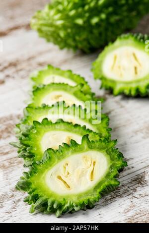 closeup of some slices of raw karela, also known as bitter melon or ...
