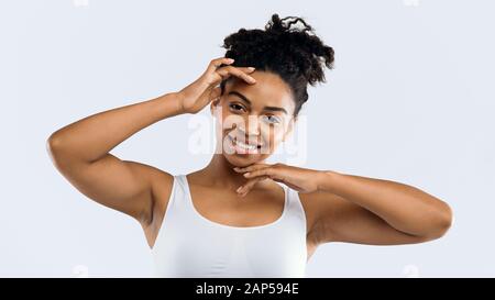 Young woman showing hairless armpits after epilation procedure on white ...
