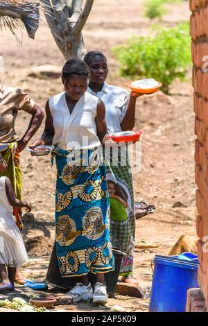 women cooking nsima or maize porridge on open fires in a Malawian ...
