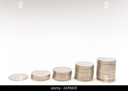 Canadian Quarters stacked into five ascending piles on white background ...