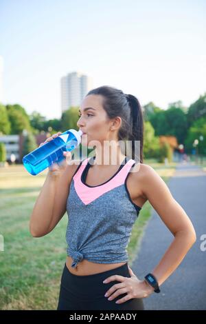 Young woman drinking water after fitness exercise Stock Photo - Alamy