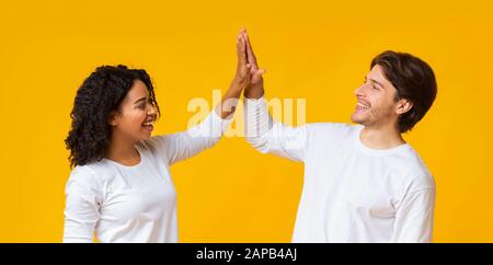 Positive couple clapping hands, giving high five over boxes Stock Photo ...