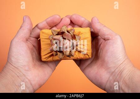 Woman's hands holding furoshiki wrapping gift box against decorating ...