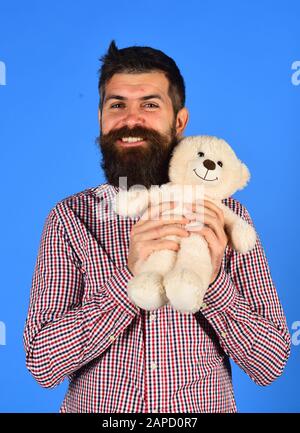 Guy with beard hugs soft toy with tenderness. Man with smiling face ...