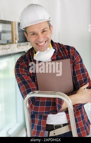 Smiling painter plastering wall with spatula in apartment Stock Photo ...