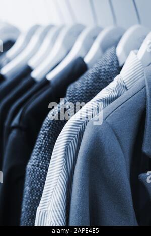 Blue coats hang on hangers in the mall. Classic women's fashion ...