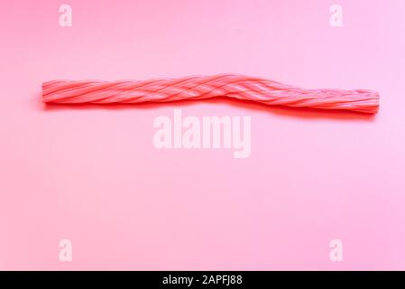 Elongated pink candy isolated on a flat colored background Stock Photo ...