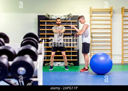 Man coaching friend in gym Stock Photo - Alamy