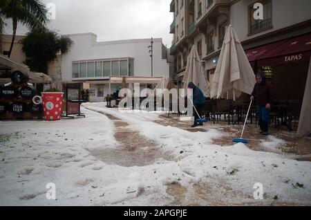 People clear hail from their workplace after a heavy hailstorm in ...