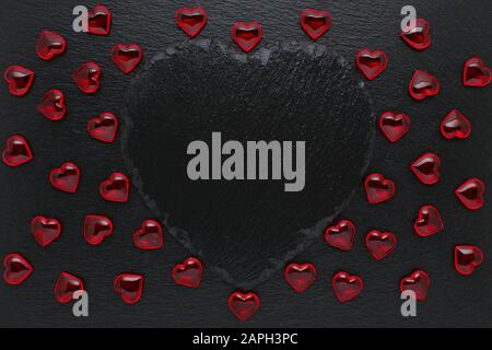 Black slate plate with red hearts on black background Stock Photo - Alamy