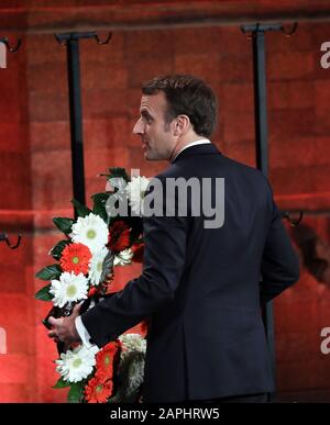 French President Emmanuel Macron lays a wreath of flowers during a ...