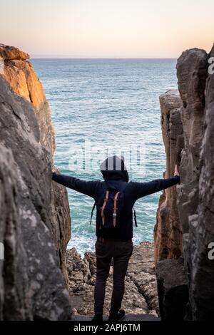 A man is standing between two rocks Stock Photo - Alamy