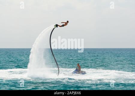 Silhouette of a fly board rider at sea and Parasailing in blue sky ...