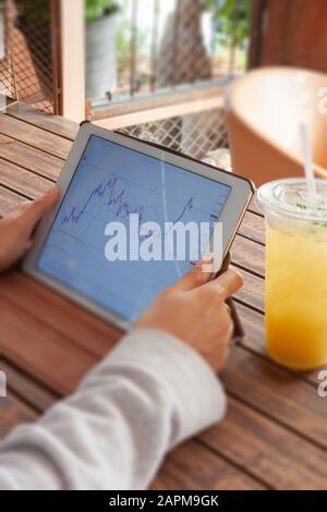 Woman hand Trading online on tablet with business paper and coffee ...
