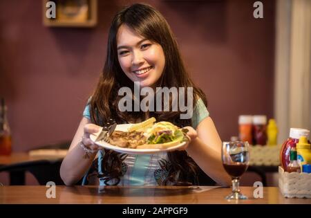 Woman eating delicious rare beef steak in restaurant Stock Photo - Alamy