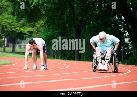 Young man racing with a handicapped senior man on a racetrack Stock ...