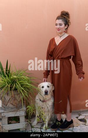 Vertical shot of a young Spanish brunette female walking through a road ...