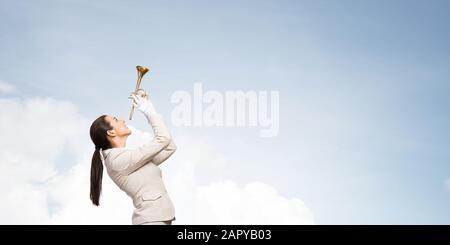 Elegant young woman playing trumpet Stock Photo - Alamy