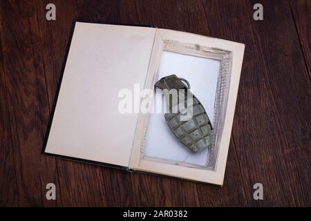 black hand grenade hidden in a book Stock Photo - Alamy