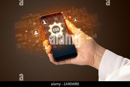 Female hand holding smartphone with CSS abbreviation, modern technology ...