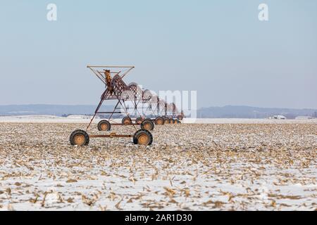 Rusty old center pivot irrigation system in cornfield with standing ...