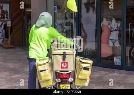 Australia Post employee postman with mail delivery trolley delivering ...