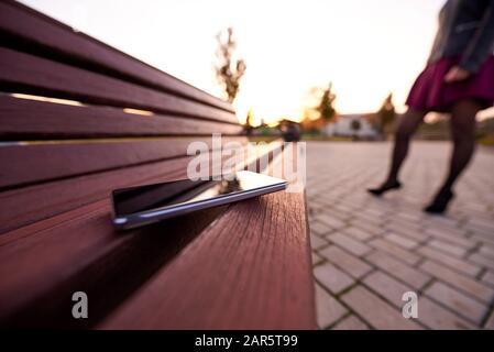forget smartphone on a park bench, lost smart phone Stock Photo - Alamy
