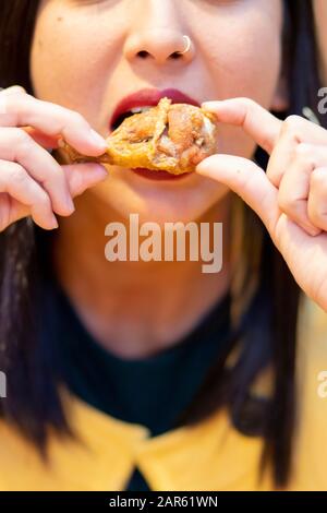 Happy woman eating chicken fingers alone in a restaurant interior Stock ...