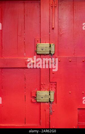 Old red gate with manual lock Stock Photo - Alamy