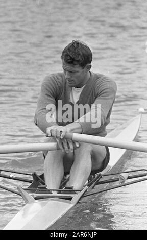 Athletes from Team New Zealand are seen on a boat waving their flag ...