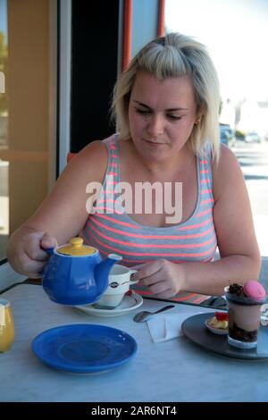 British woman pouring and drinking a cup of tea, UK Stock Photo - Alamy